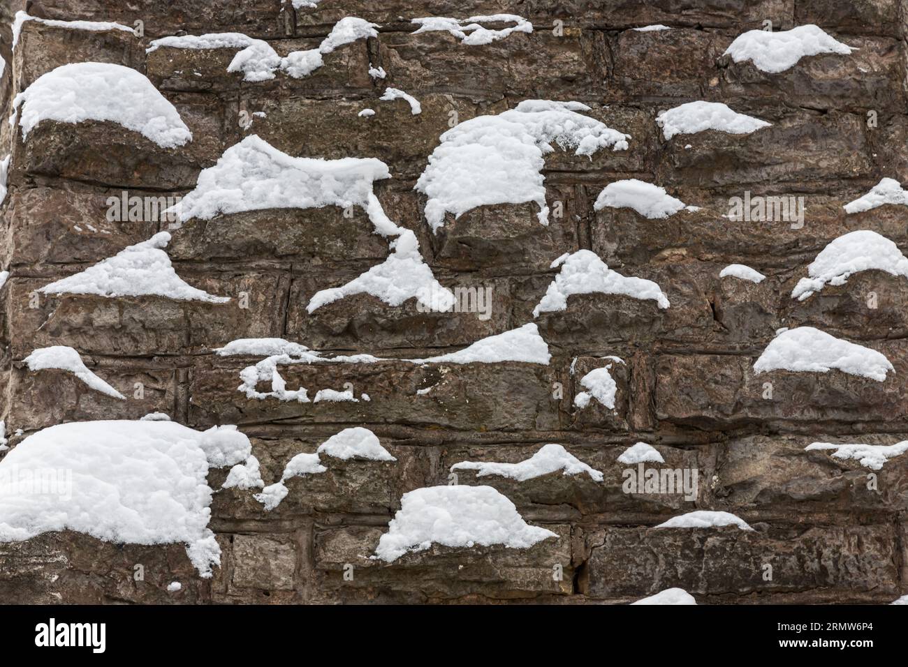 Medieval stone wall is covered with snow, design background with place ...