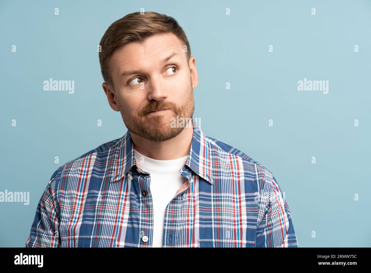 Pensive middle aged man pursing lips look in the upper right corner ...