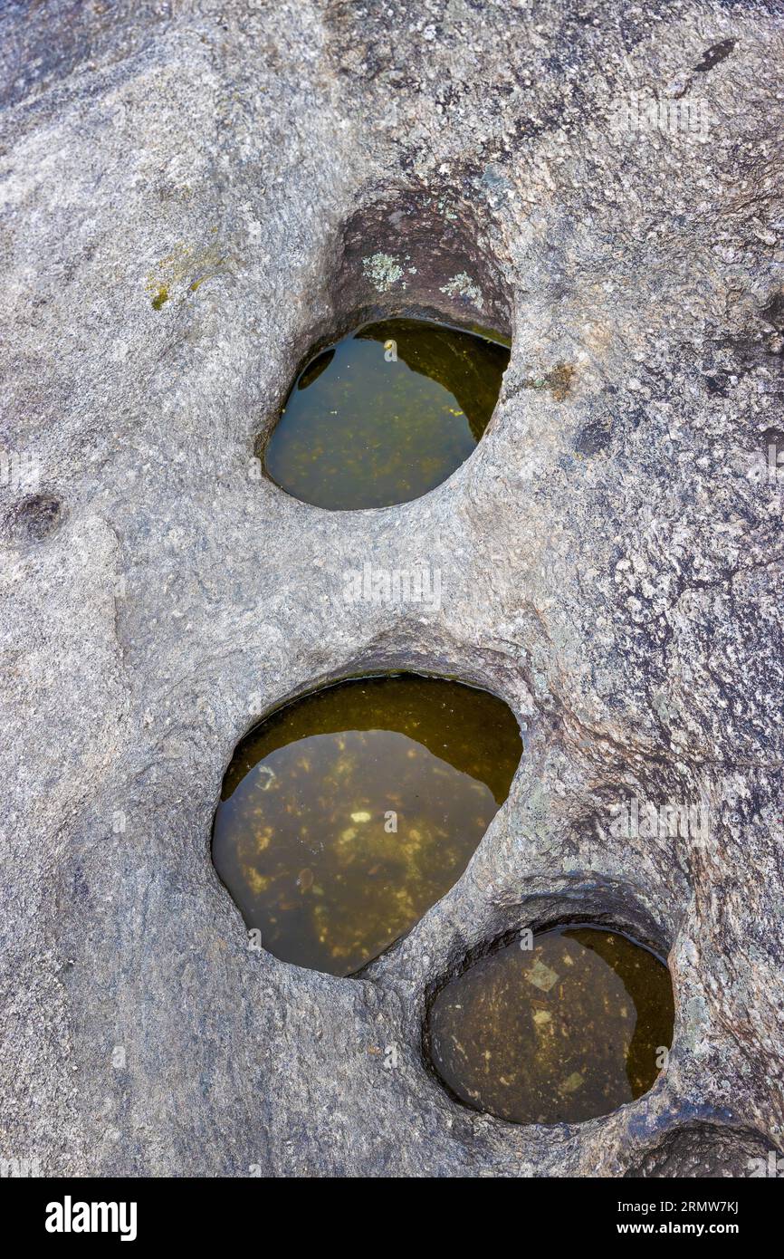 At the top of Chimney Rock holes have formed in the rock and rain water ...