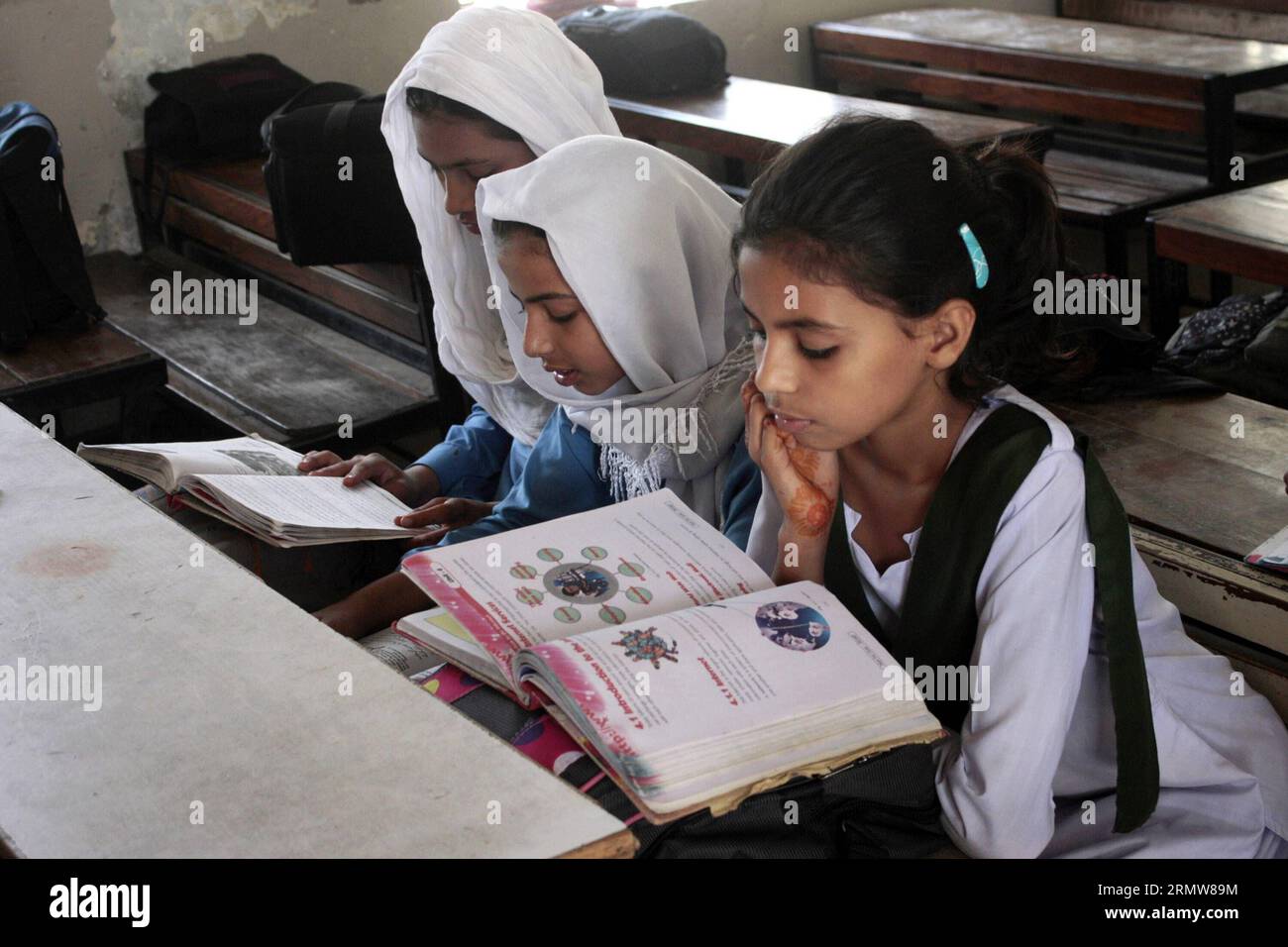 Pakistani girls attend a class at a government school in eastern ...