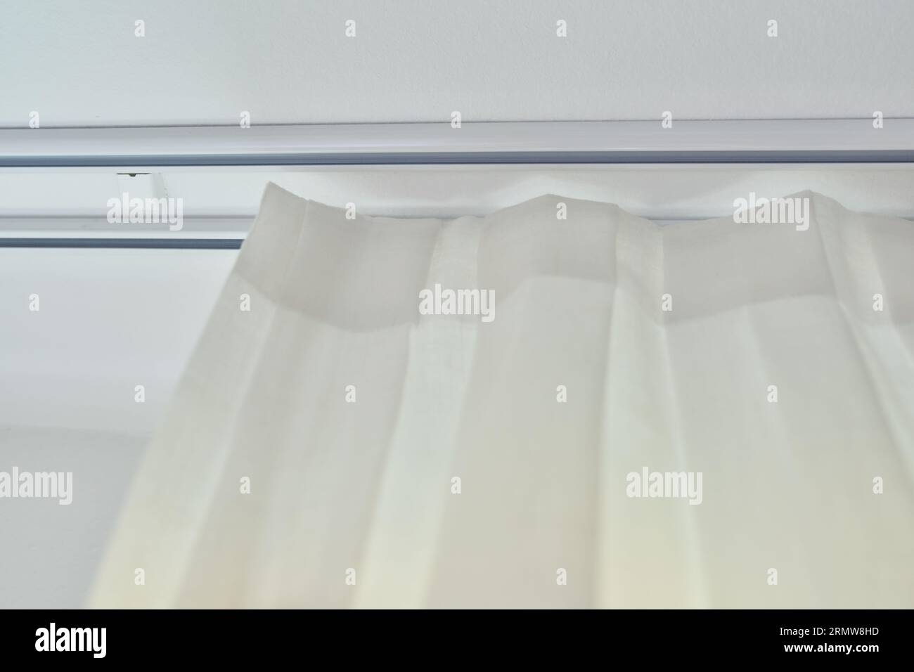 Translucent white textured curtain on window, close-up of cornice and ...