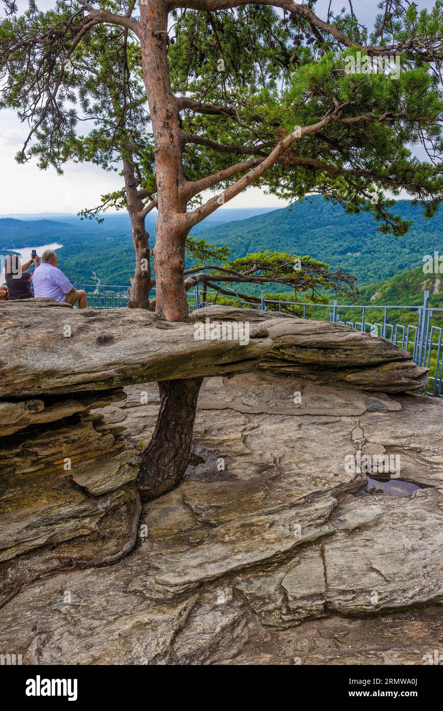 Chimney Rock, North Carolina, USA - August 11, 2023:A couple sits on ...