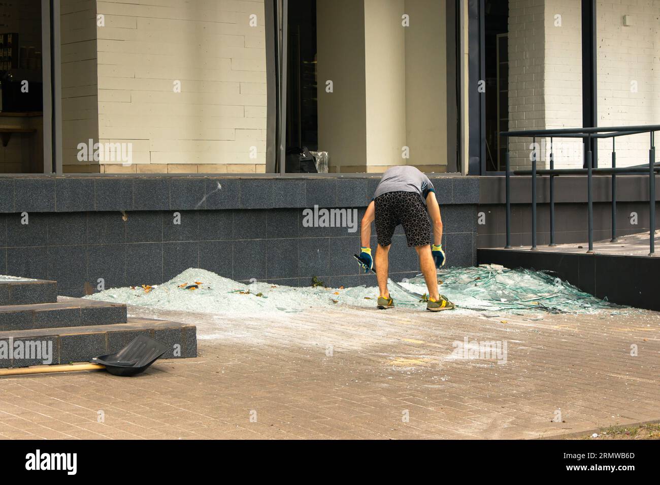 Man cleaning up broken after missile attack in Kyiv, Ukraine, august ...