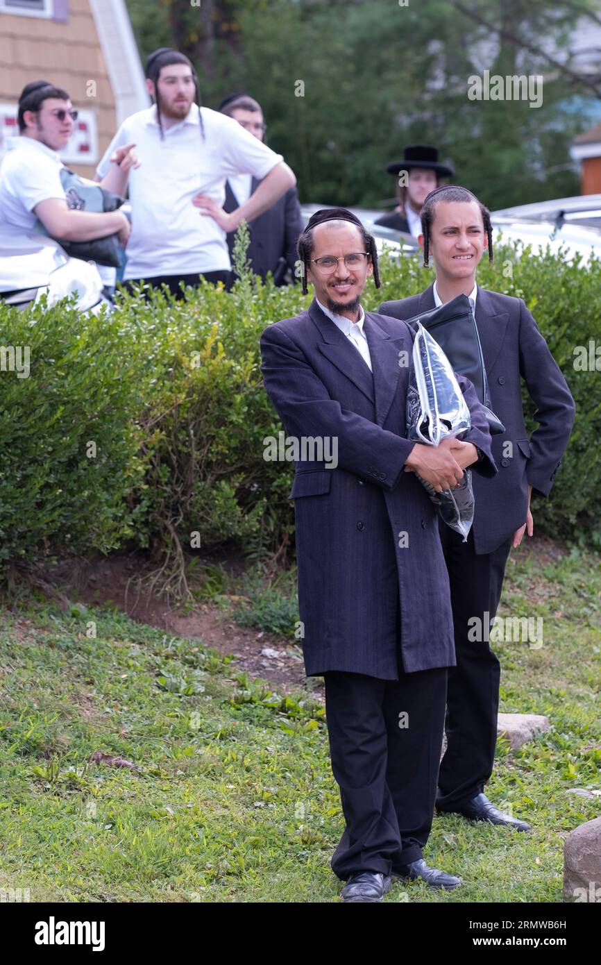 Several young orthodox Jewish men stand outside a synagogue in Monsey ...