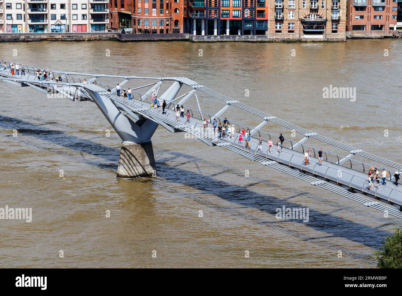 Pedestrians walking across the Millennium Bridge over the River Thames ...