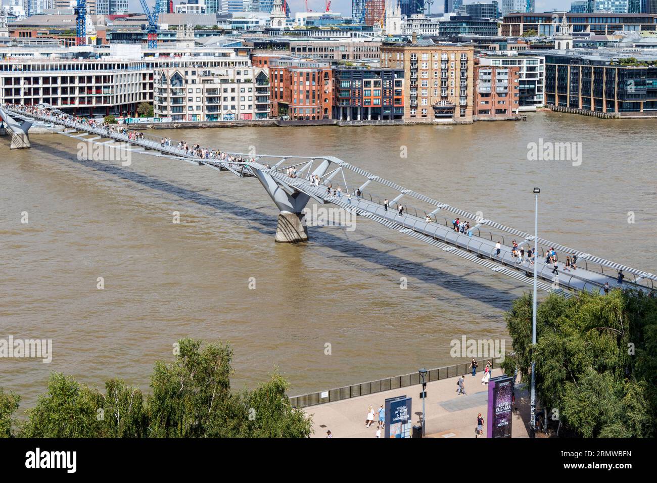 Pedestrians walking across the Millennium Bridge over the River Thames ...