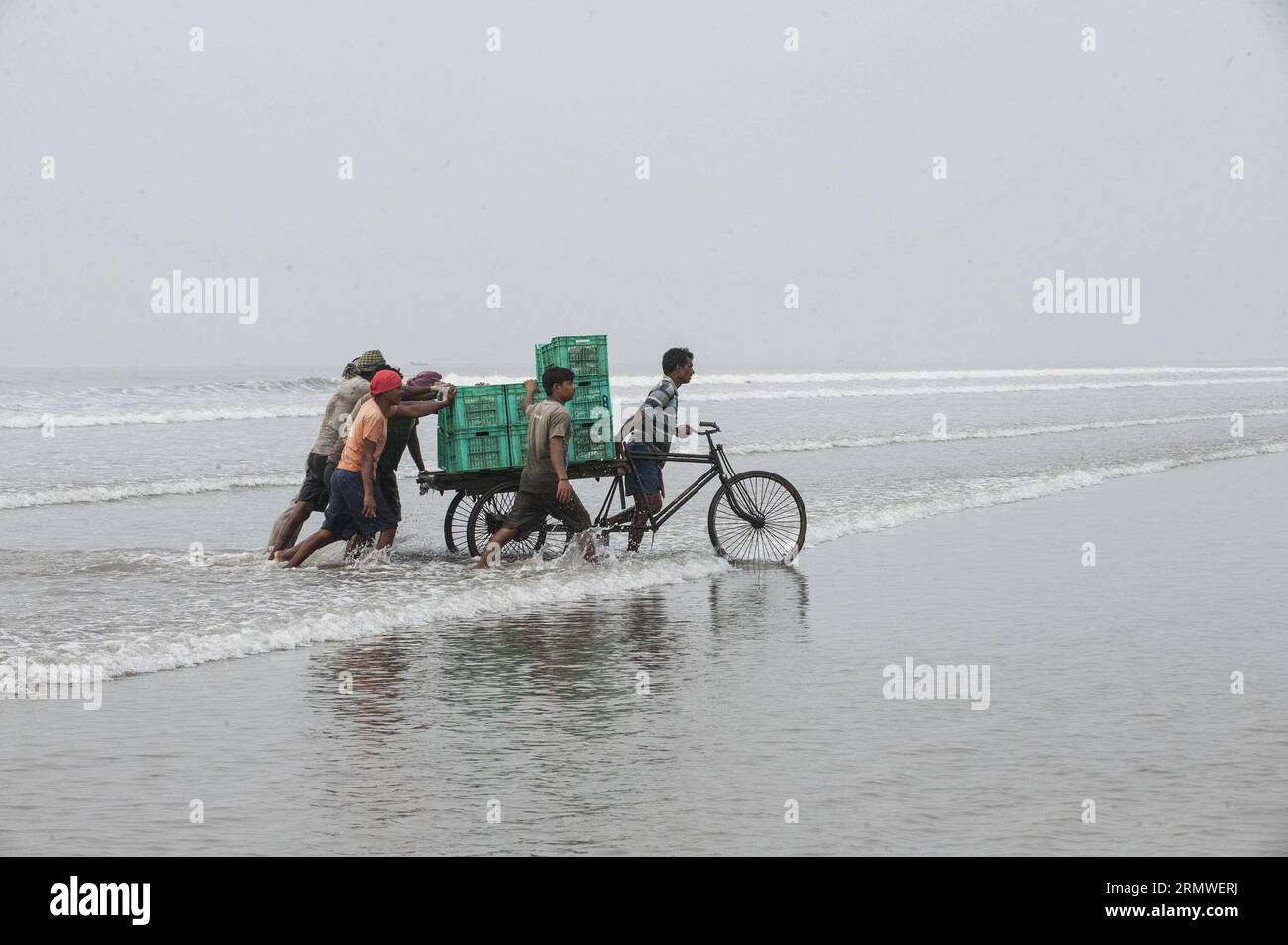 (141026) -- CALCUTTA, Oct. 26, 2014 -- Indian fishermen walk through ...