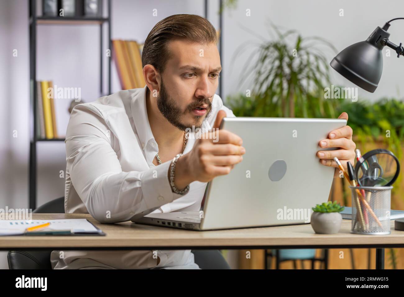 Irritated tired middle eastern business man while working on laptop ...
