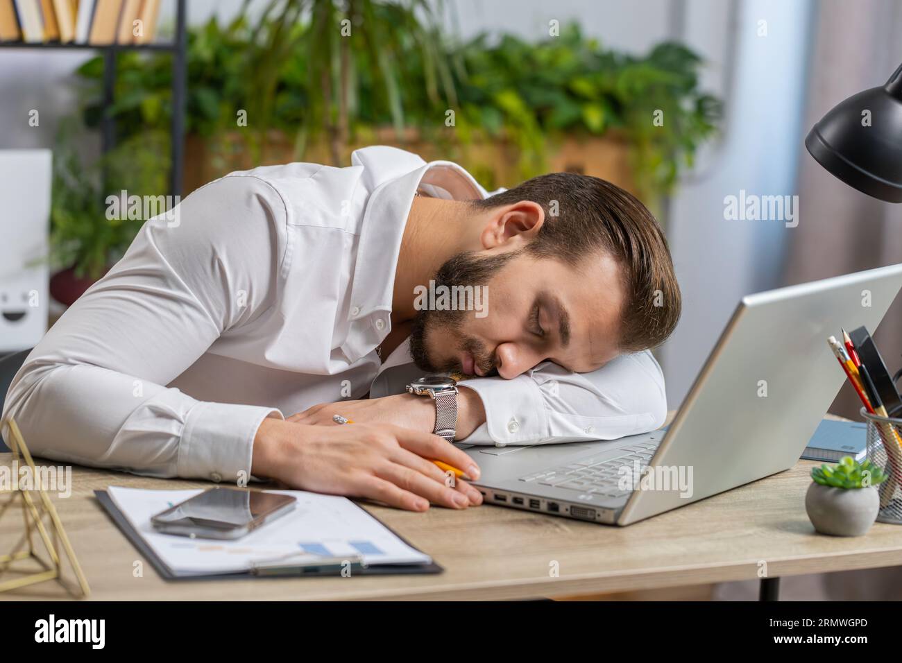 Bored sleepy middle eastern businessman worker working on laptop ...