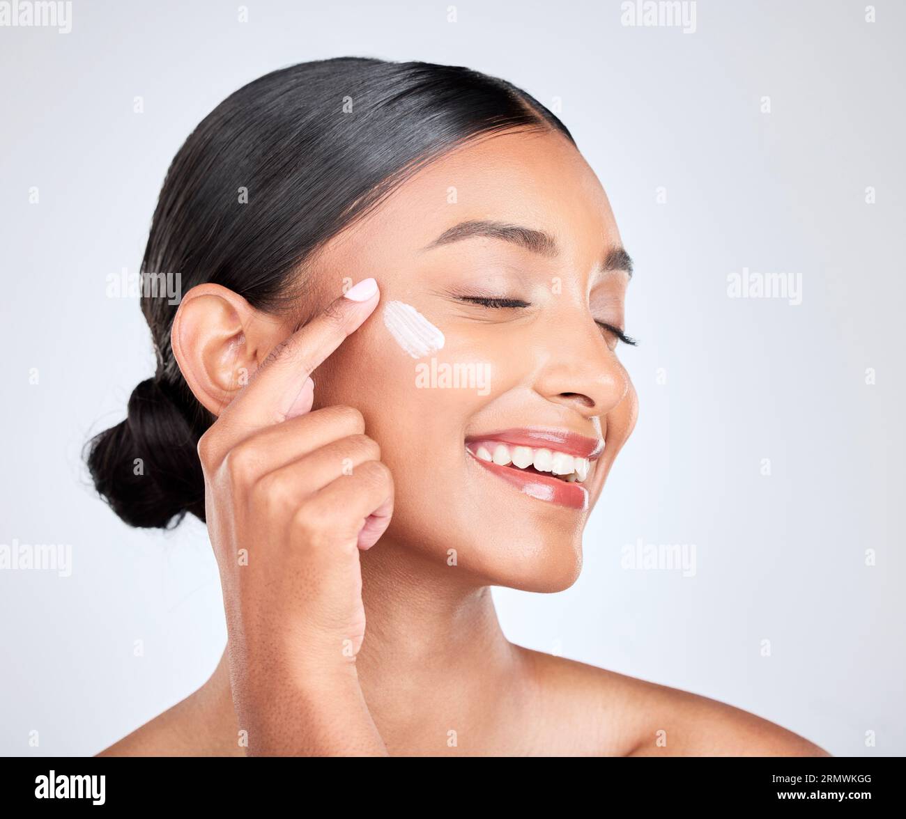 Smile, cream and woman with beauty, cosmetics or apply lotion on a white studio background ...