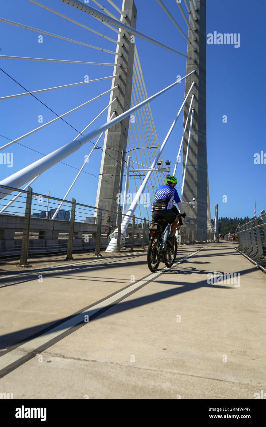 Man riding bike across the Willamette River on the Tillicum Crossing ...