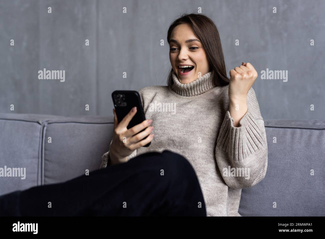 Surprised woman with open mouth looking at phone screen, reading ...