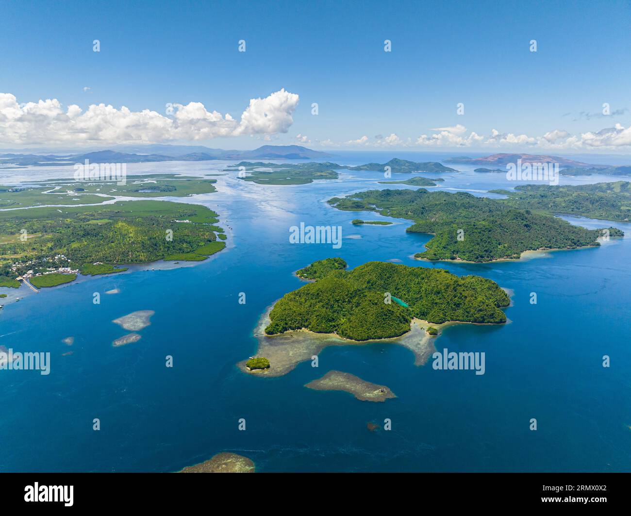 Air survey of tropical islands and azure water and blue sky and clouds ...