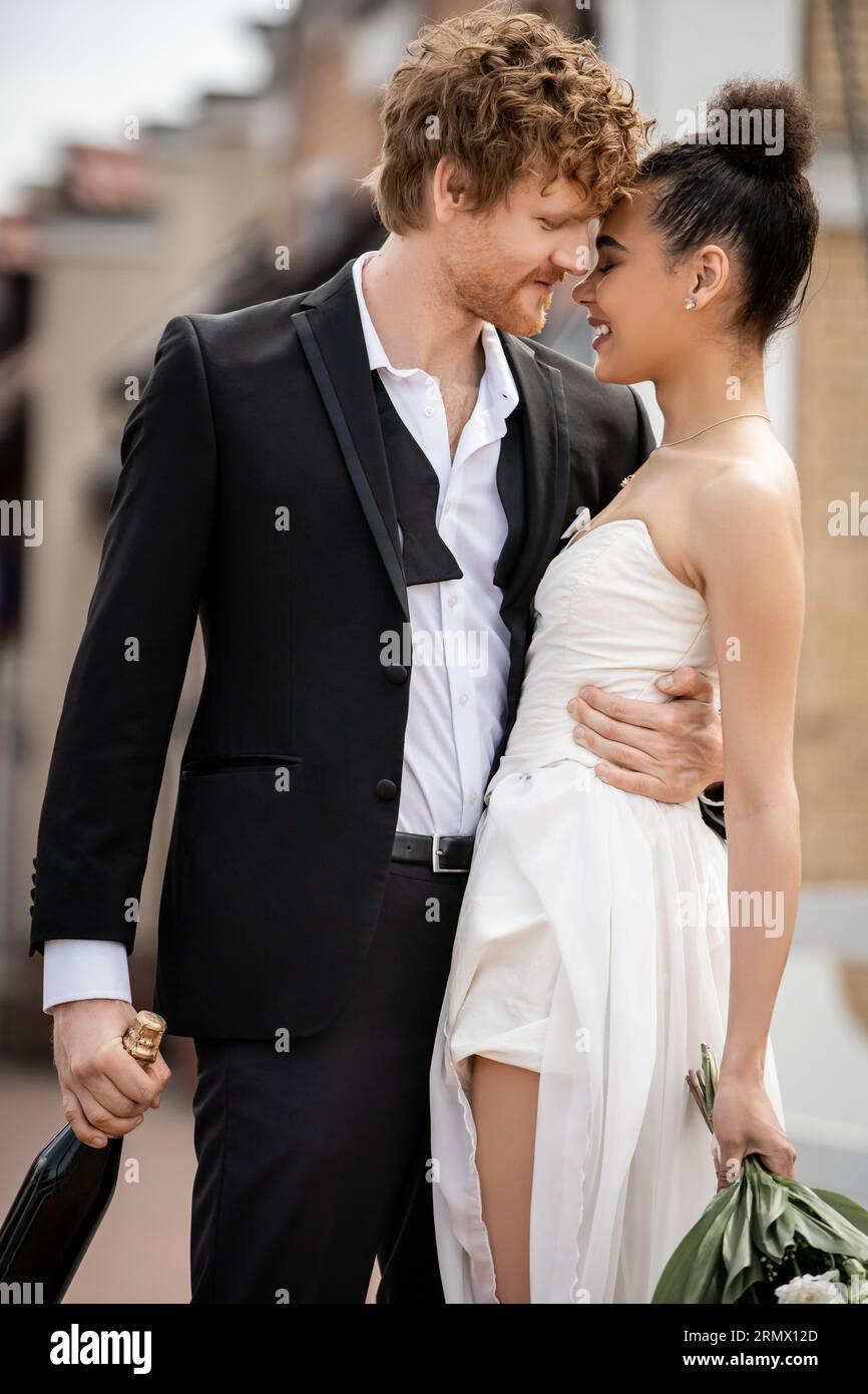 young redhead man in elegant suit embracing happy african american ...