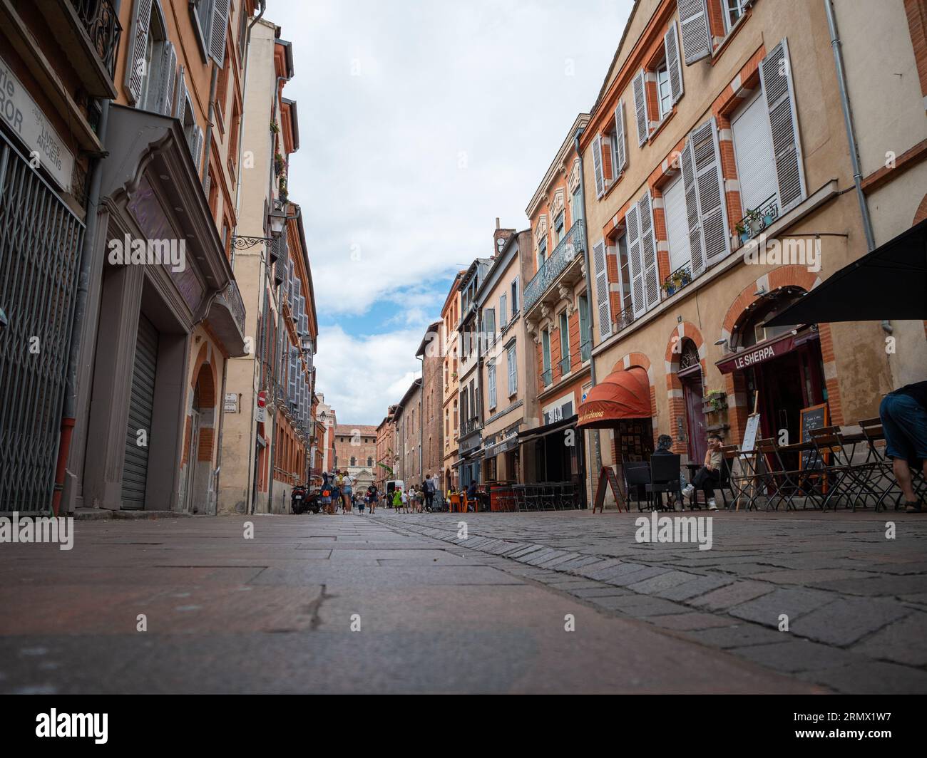 A bustling city street in Toulouse, France, featuring a series of ...