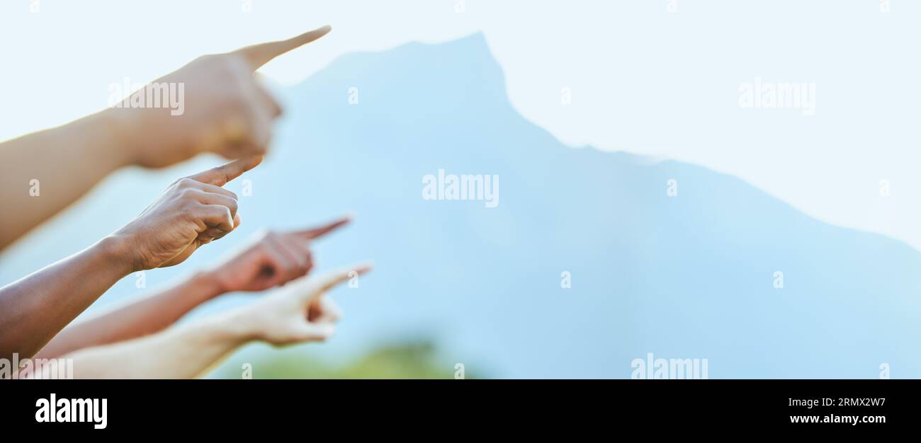 Hands, group and pointing outdoor to mockup space, advertising or ...