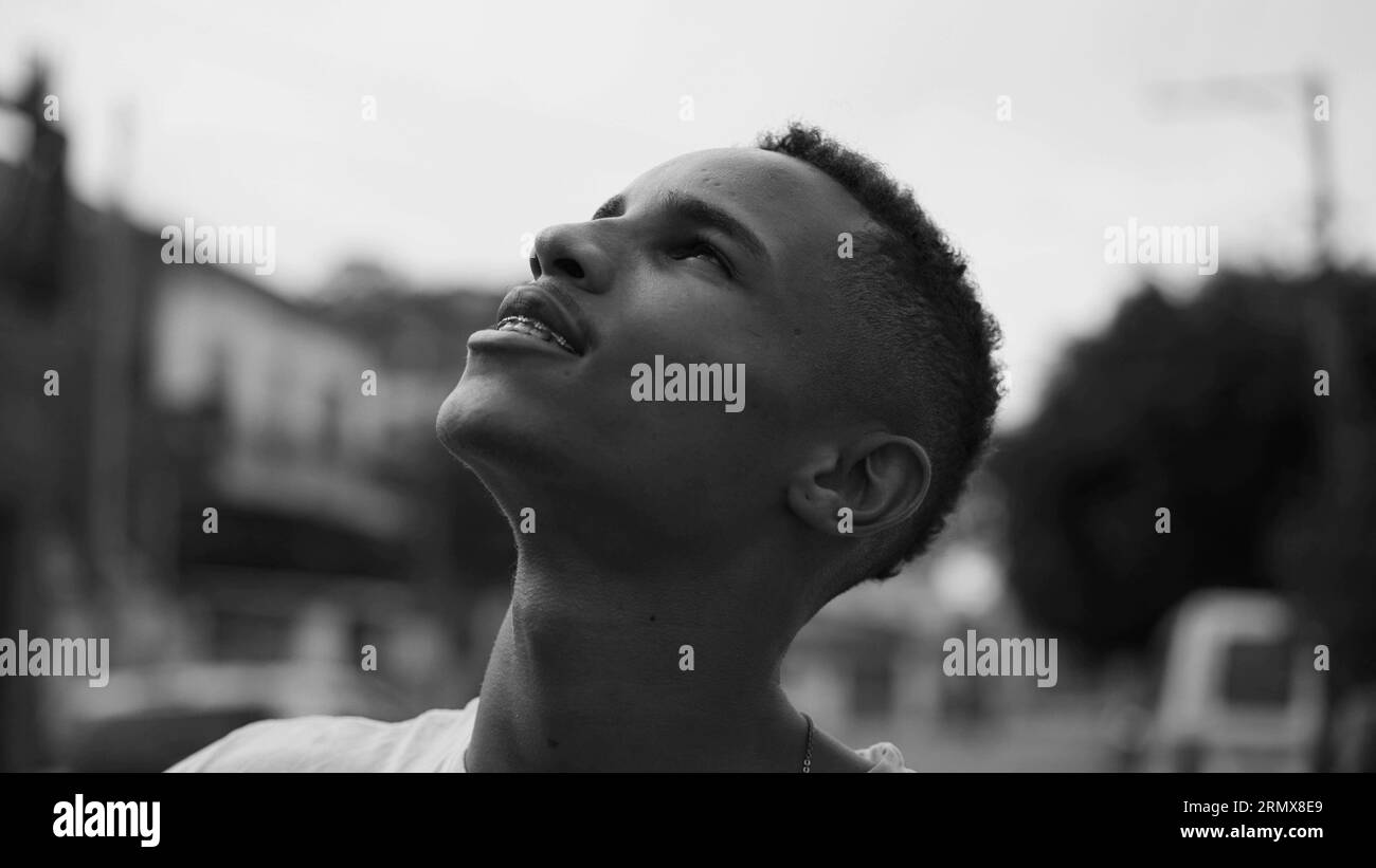 One faithful African American man looking up at sky with HOPE. Smiling ...