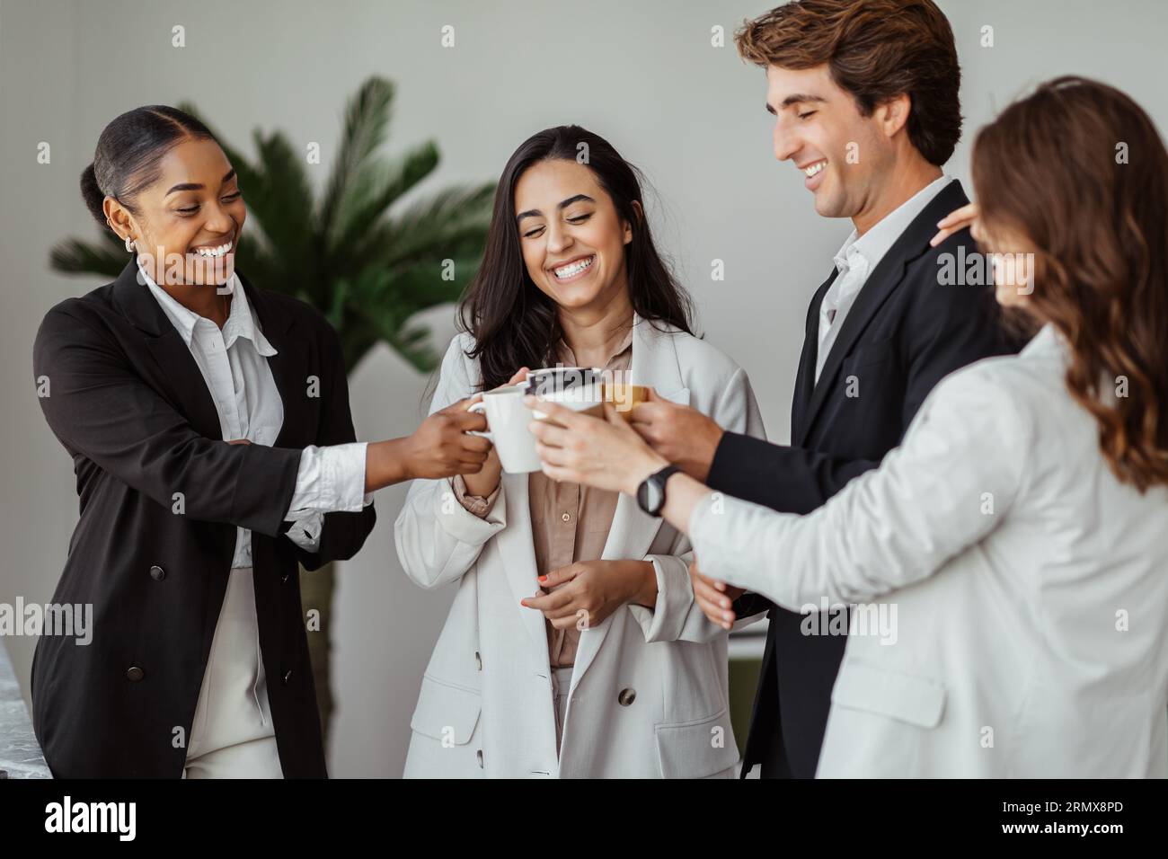 Happy multiracial male and female colleagues drinking coffee during ...