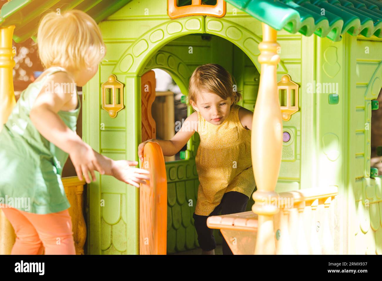 Little girl being absorbed playing in a hut Stock Photo - Alamy