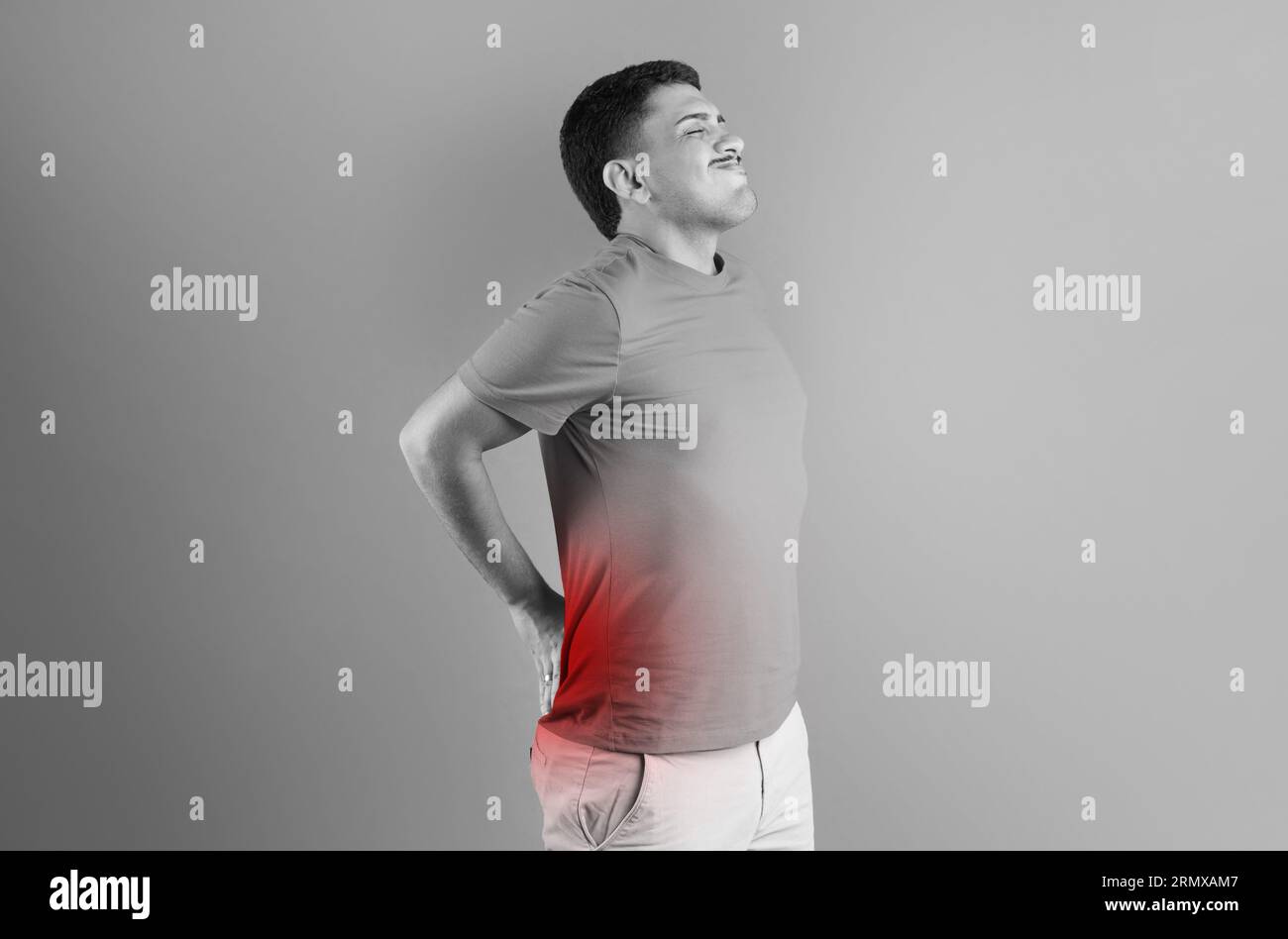 Brazilian man touching aching lower back with red spot on spine ...