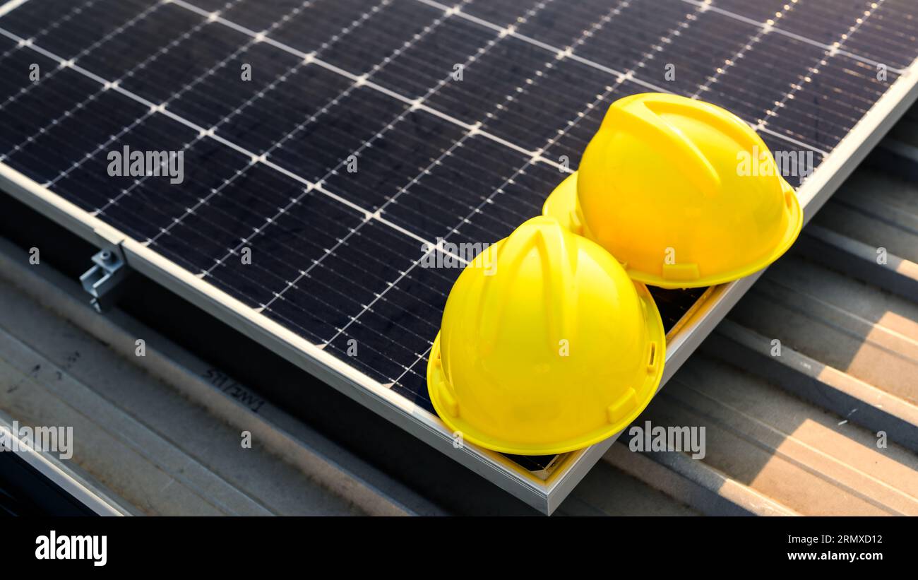 Engineer helmet on blue photovoltaic solar panels at solar cell farm ...