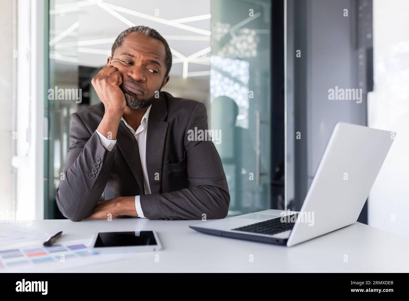 Bored businessman working on boring work project inside office with ...