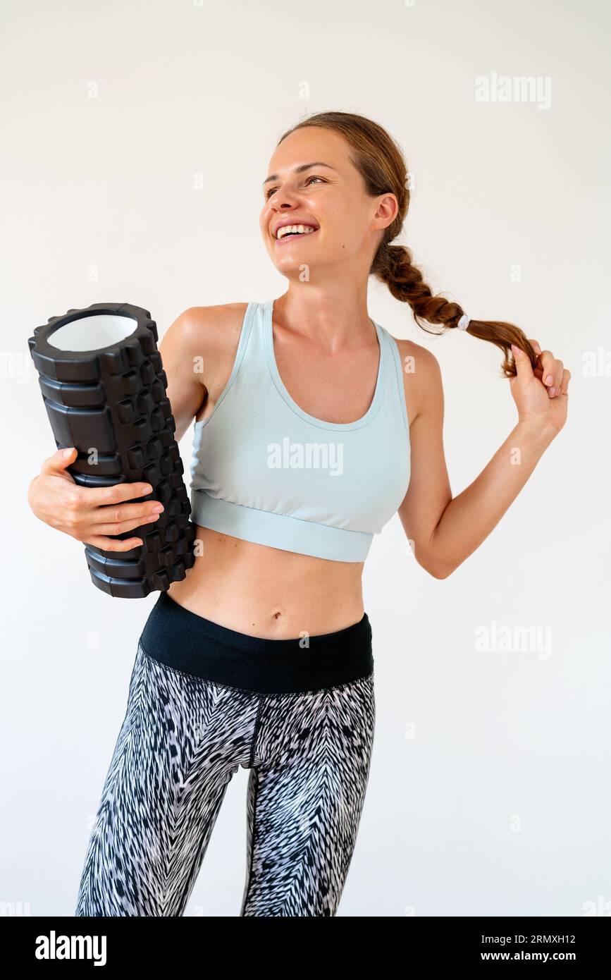 Happy female fitness athlete posing in front of white background with ...