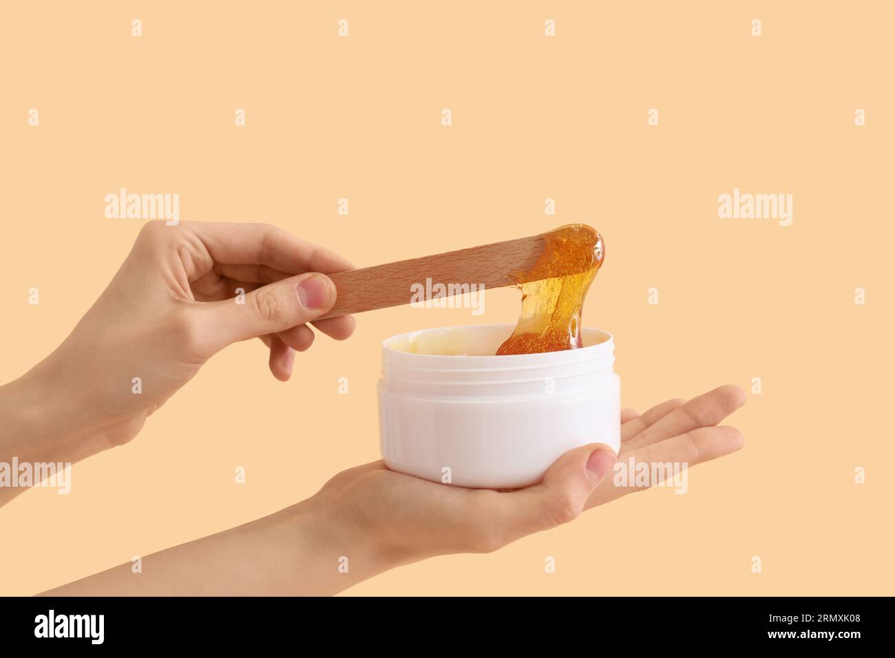 Female hands holding sugaring paste on beige background Stock Photo - Alamy