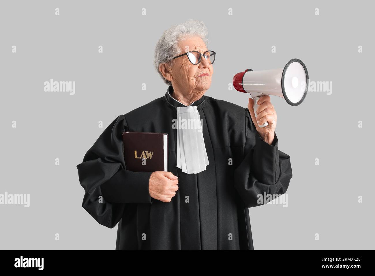 Senior judge with law book and megaphone on grey background Stock Photo ...