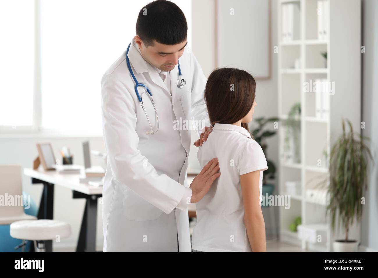 Doctor checking posture of little girl in clinic Stock Photo - Alamy