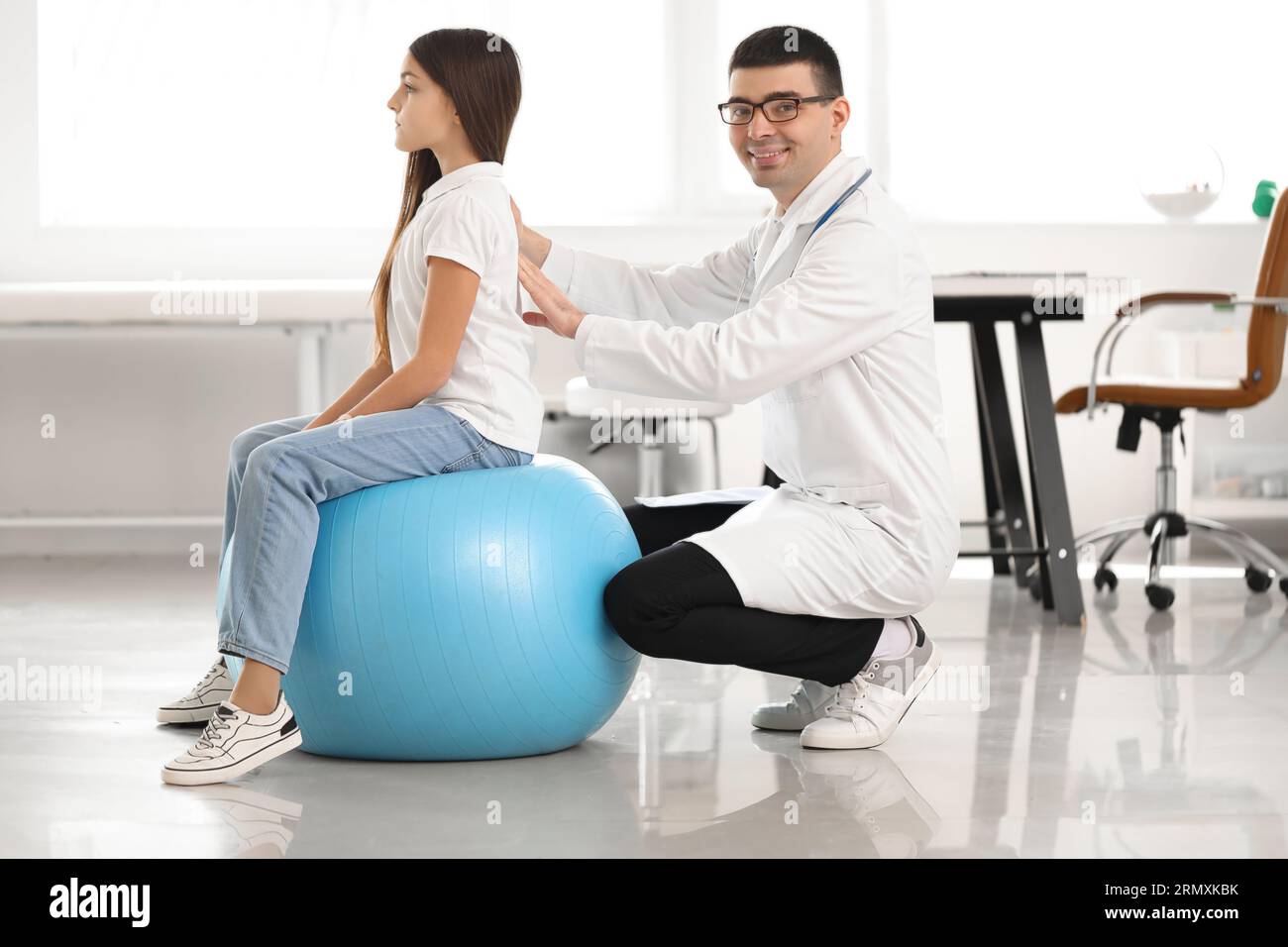 Doctor checking posture of little girl in clinic Stock Photo - Alamy
