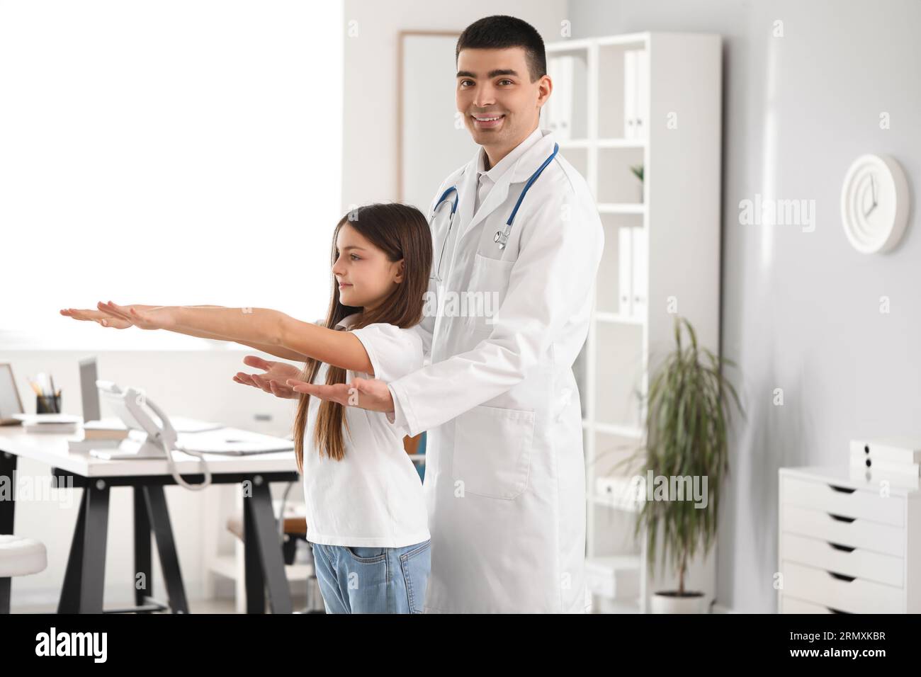 Doctor checking posture of little girl in clinic Stock Photo - Alamy