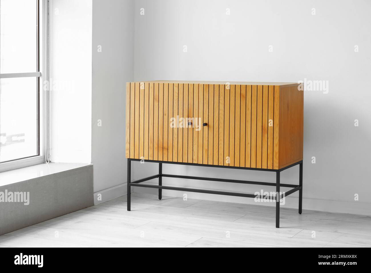 Stylish wooden cabinet near big window Stock Photo - Alamy