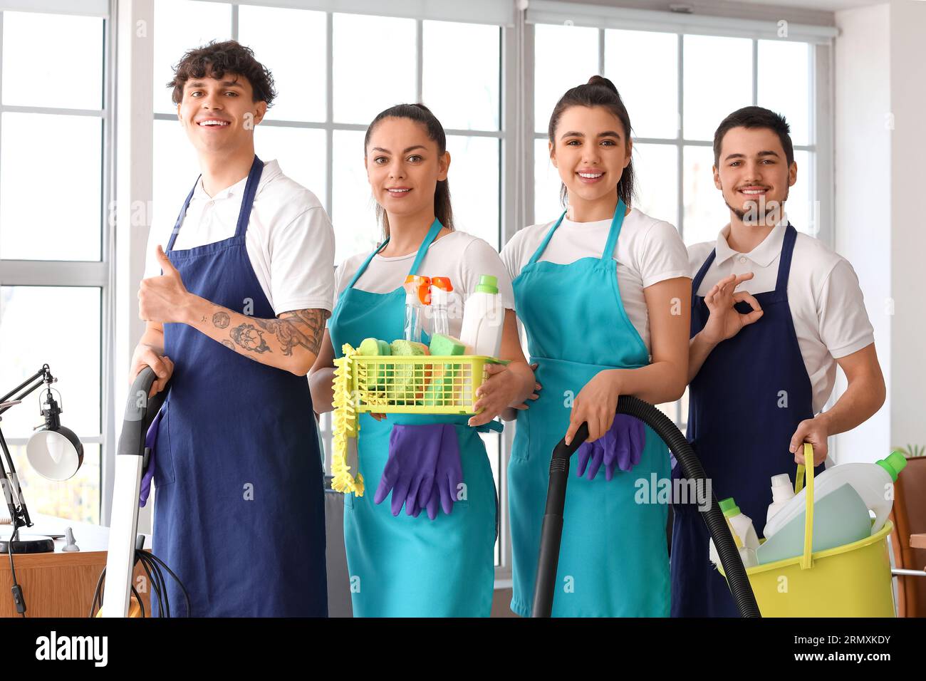 Young janitors with cleaning supplies in office Stock Photo - Alamy