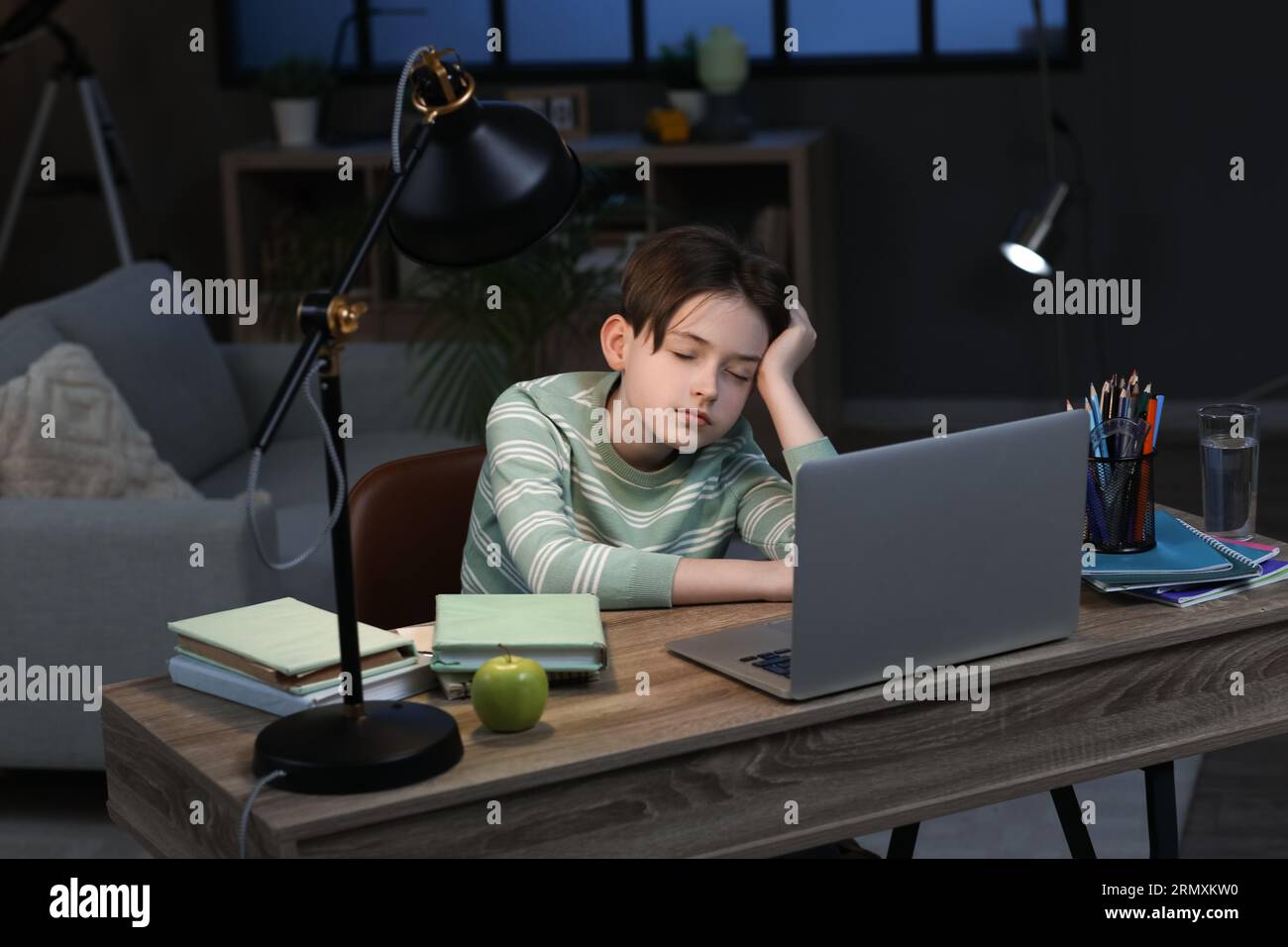 Sleepy little boy with doing homework at home late in evening Stock ...
