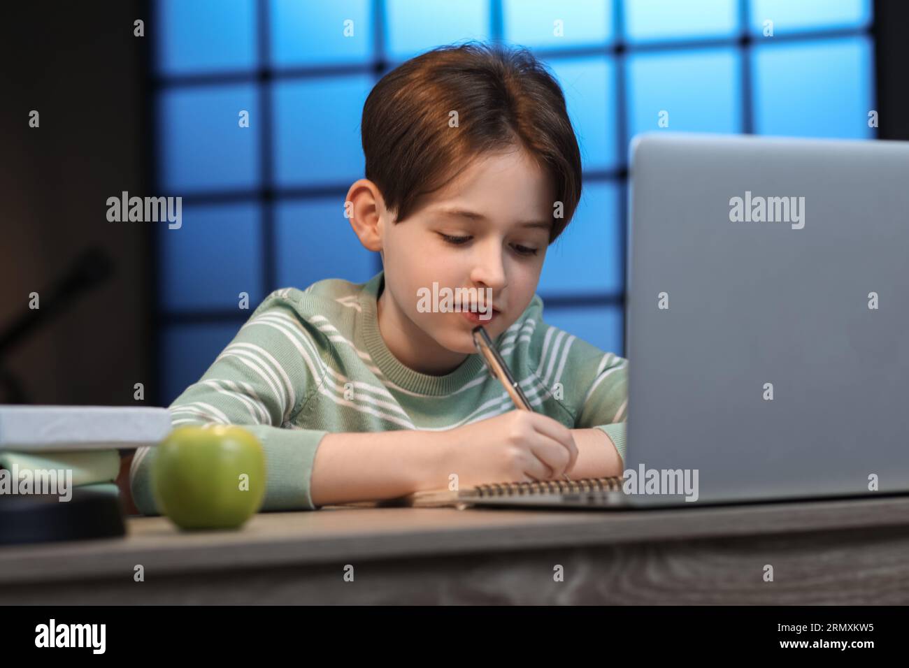 Little boy doing homework with laptop at home late in evening Stock ...