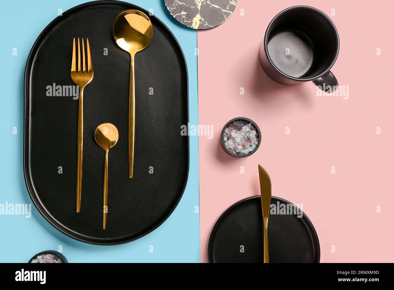 Table setting with clean plates, set of golden cutlery, cup and drink ...