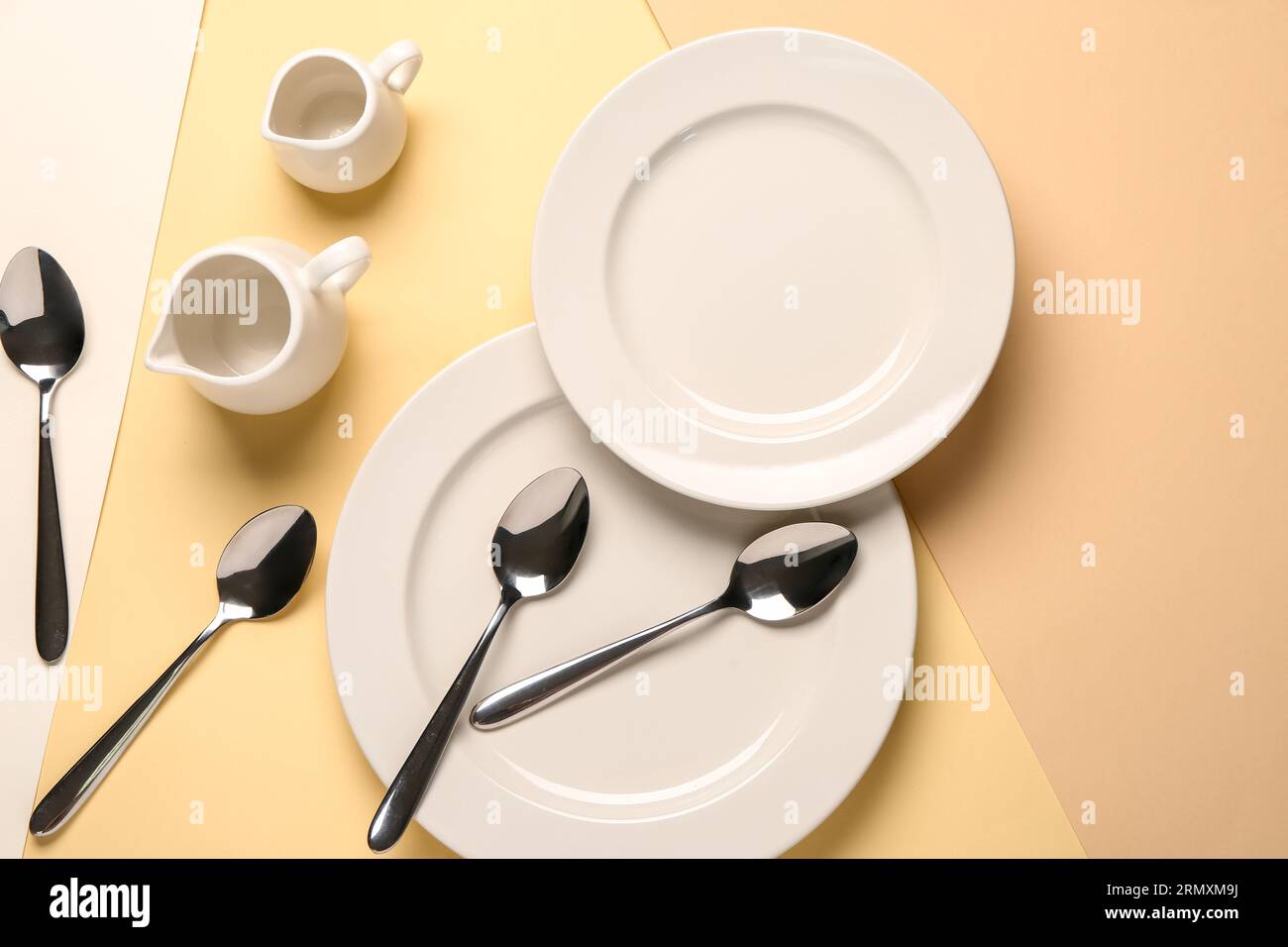 Clean plates, set of spoons and pitchers on beige background Stock ...