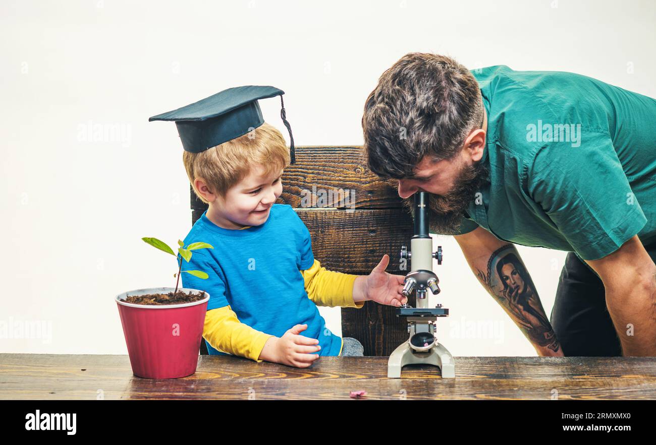 Biology lesson in primary school. Little child boy in graduation hat ...