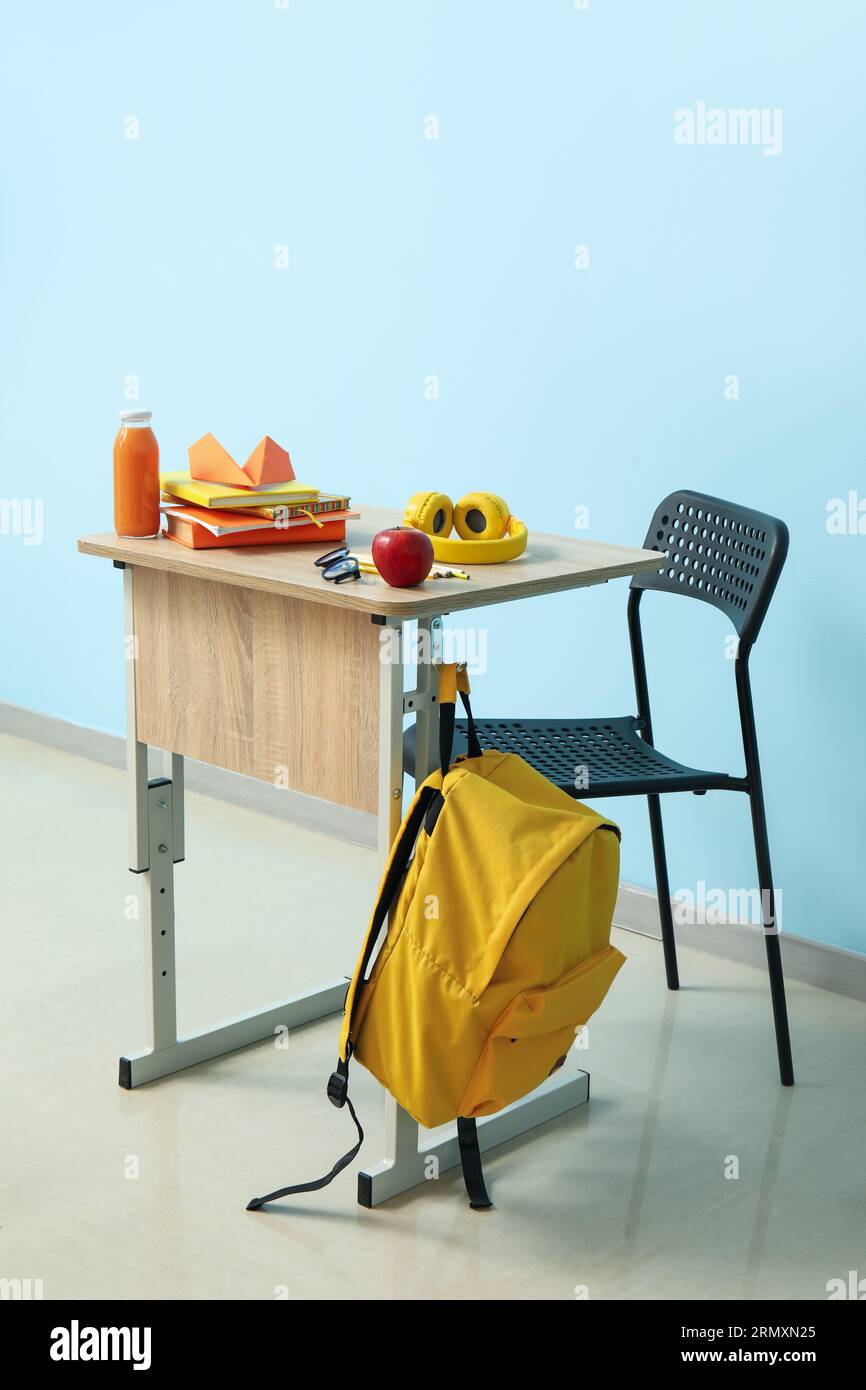 Modern school desk with backpack, stationery and lunch in room near ...