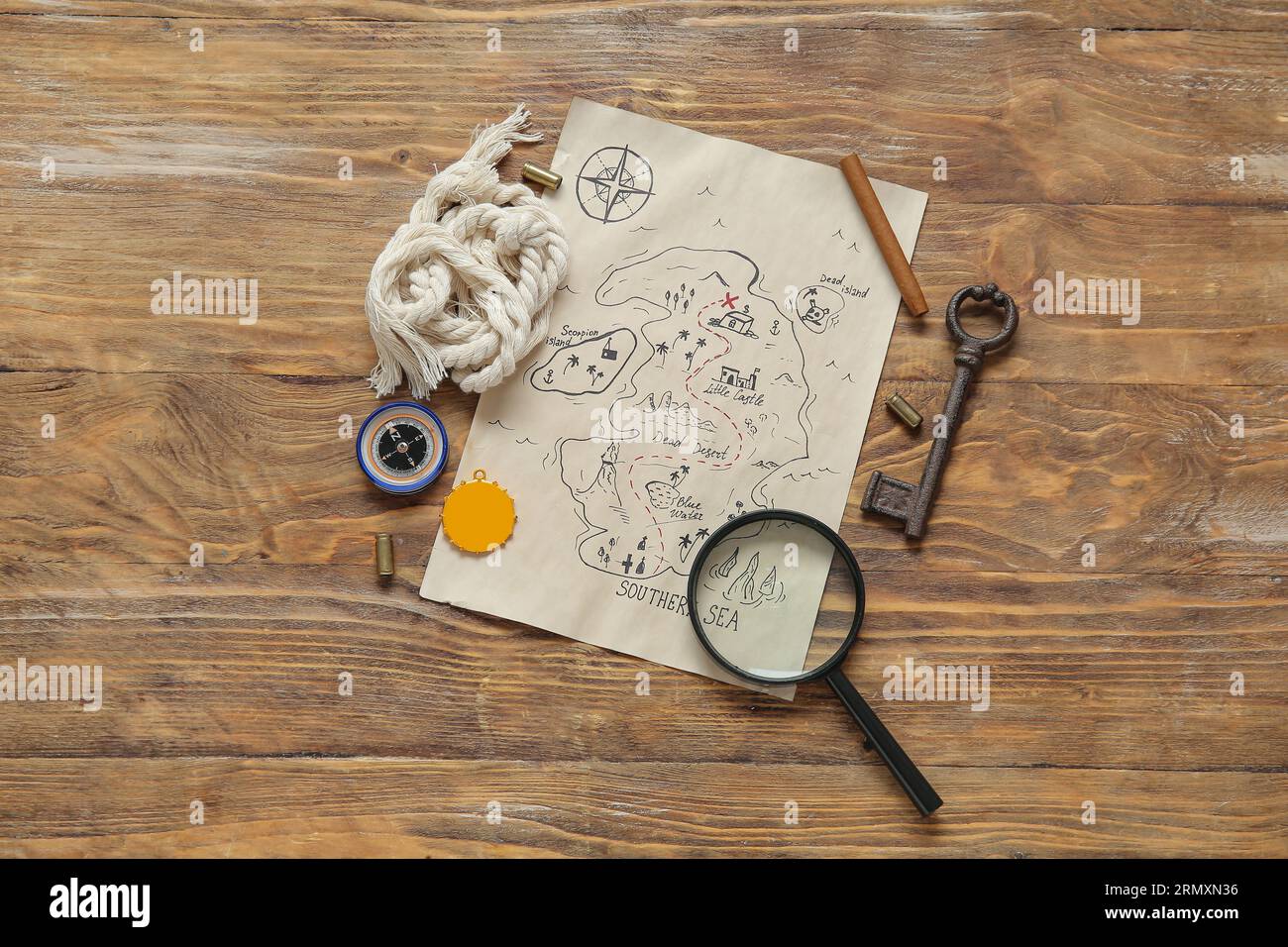 Treasure map with pirate amulet and travel equipment on brown wooden ...