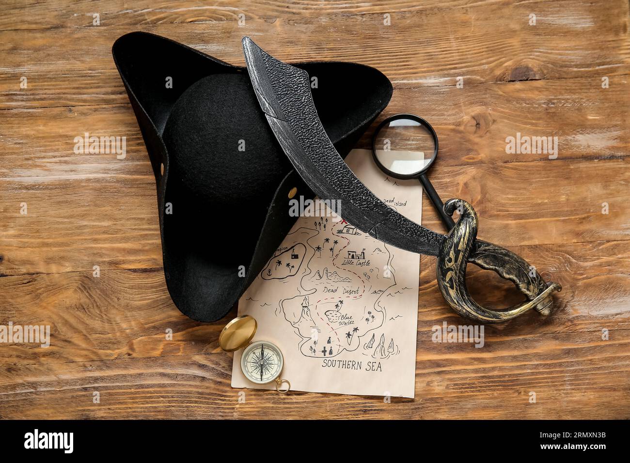 Treasure map with pirate hat, sword, magnifier and compass on brown ...