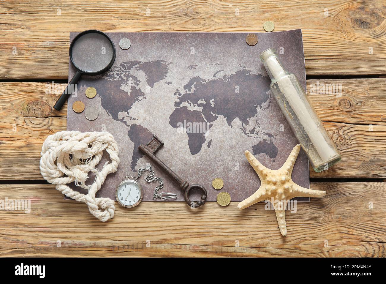 World map with scroll, magnifier, coins and pocket watch on brown ...