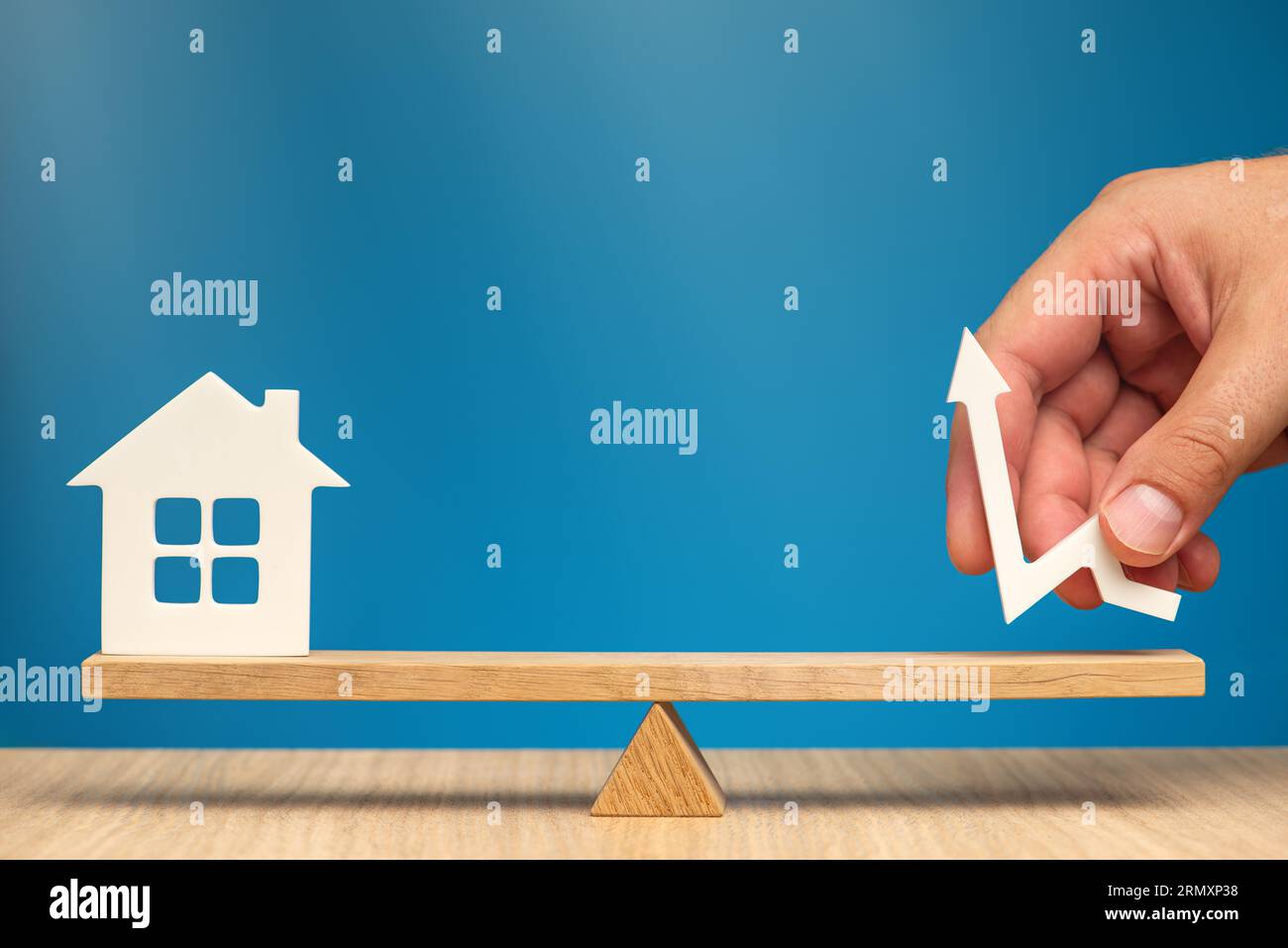 Rising property values. House model and arrow in hand pointing up ...