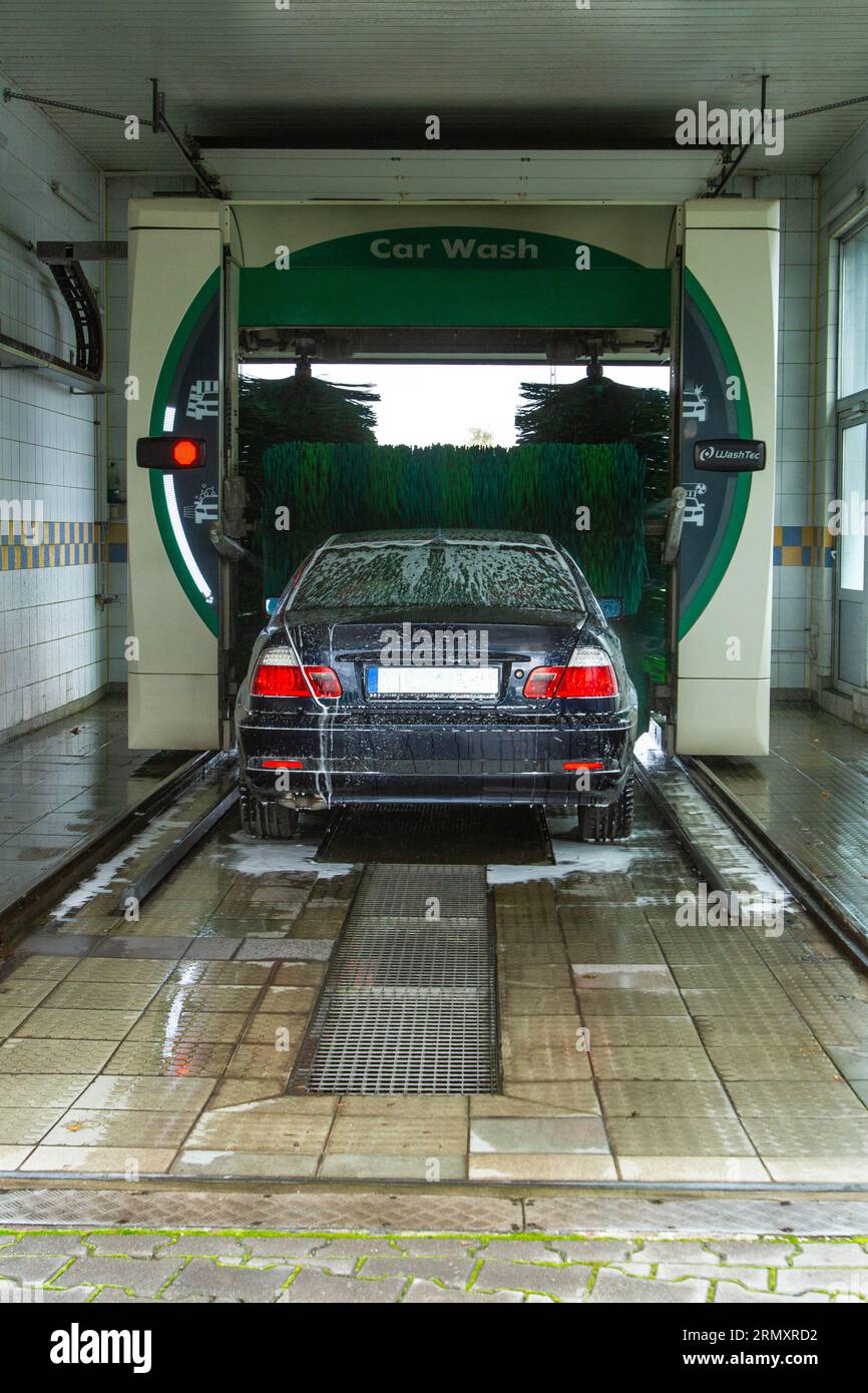 An automatic car wash with a passenger car in the process of getting ...