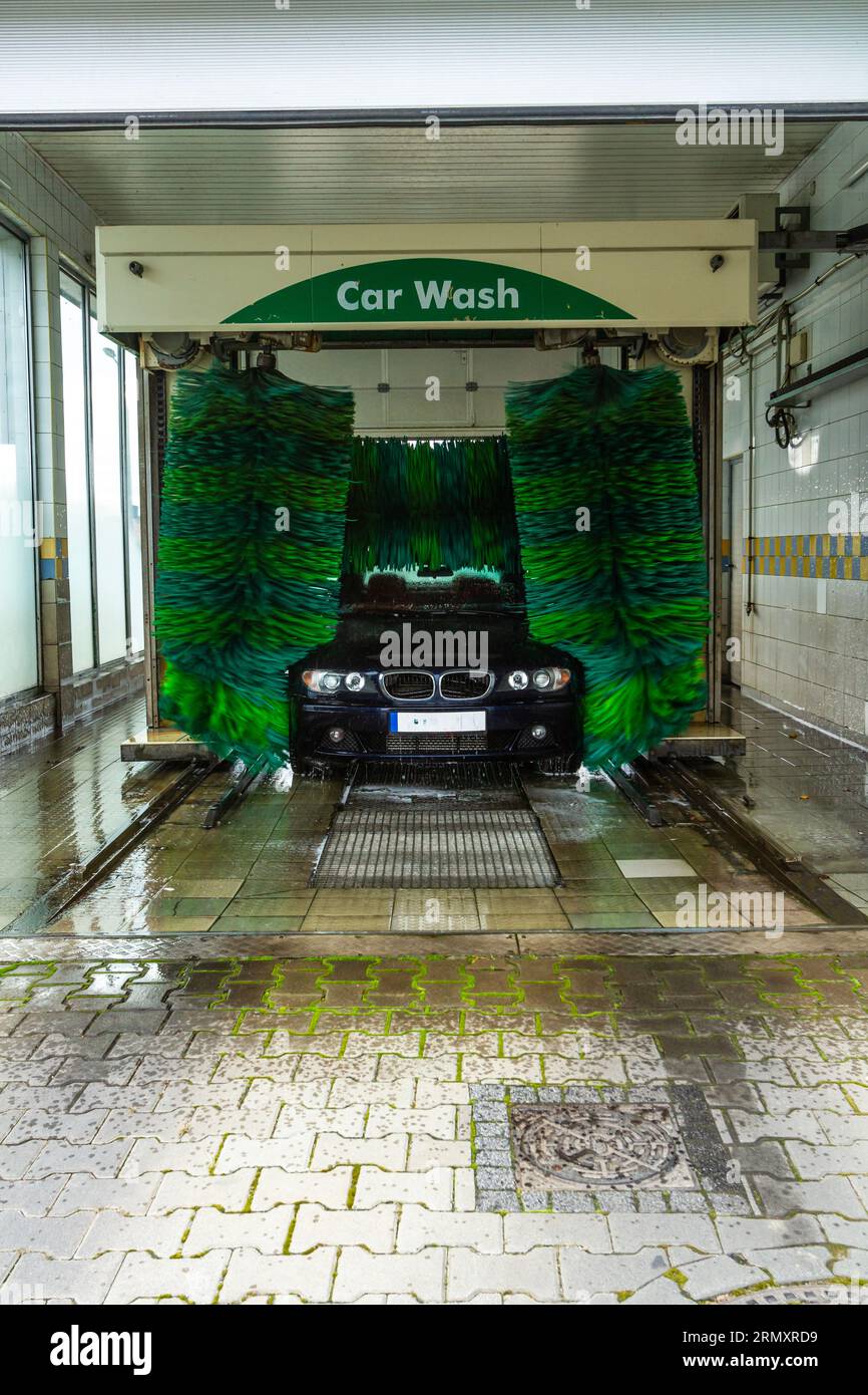 An automatic car wash with a passenger car in the process of getting ...