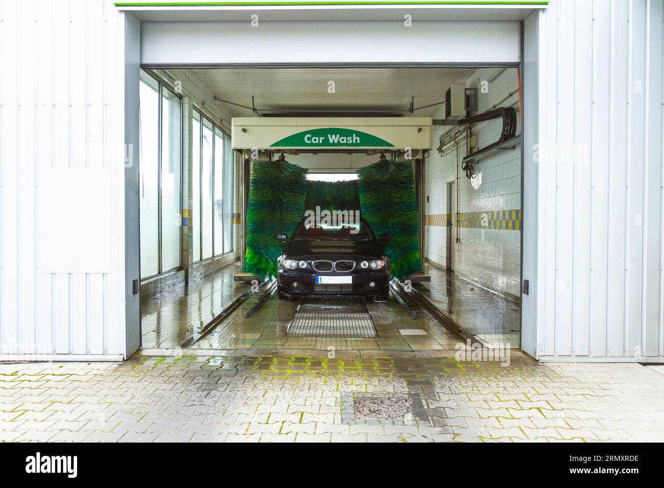 An automatic car wash with a passenger car in the process of getting ...