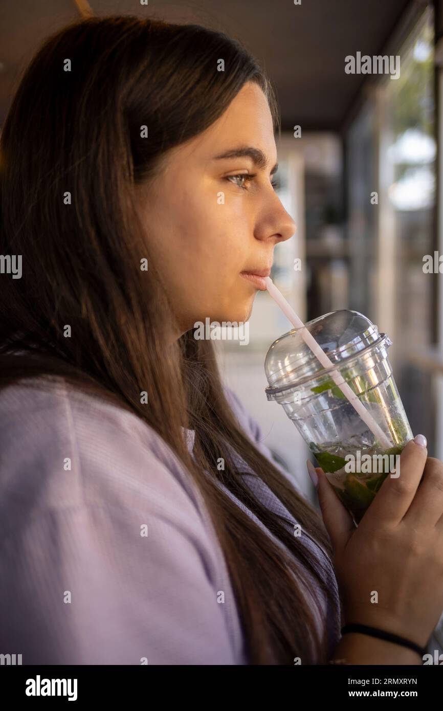 A girl with a plastic glass of a cool drink Stock Photo - Alamy