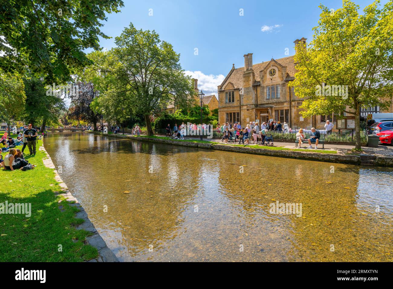 Pedestrians walk along the River Windrush at picturesque Bourton-on-the ...