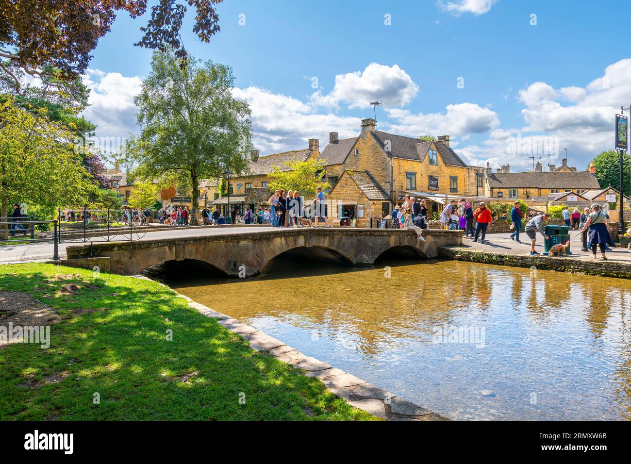 Pedestrians walk along the River Windrush at picturesque Bourton-on-the ...